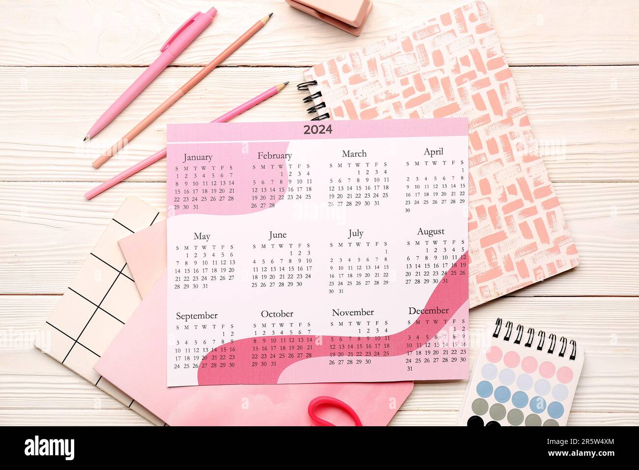 Calendar, notebooks, color palette and stationary on white wooden ...