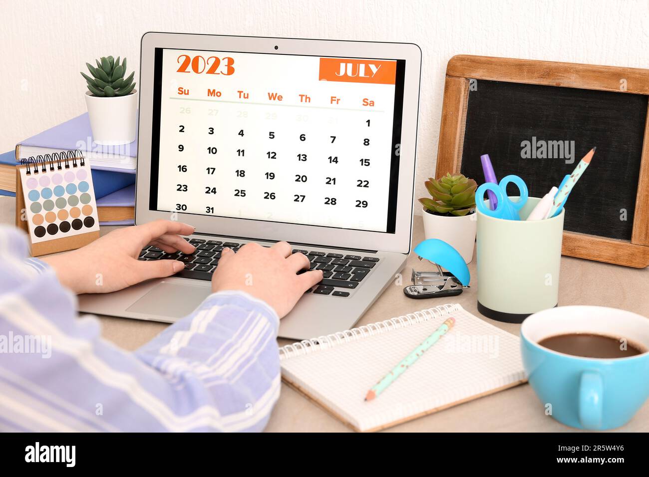 Woman using modern laptop with calendar at workplace Stock Photo - Alamy