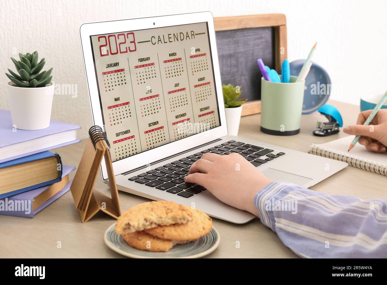 Woman using modern laptop with calendar at workplace Stock Photo - Alamy