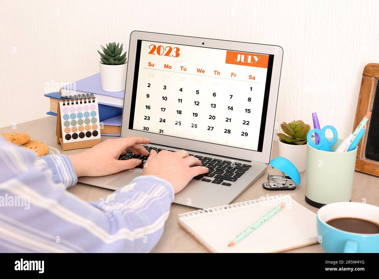 Woman using modern laptop with calendar at workplace Stock Photo - Alamy