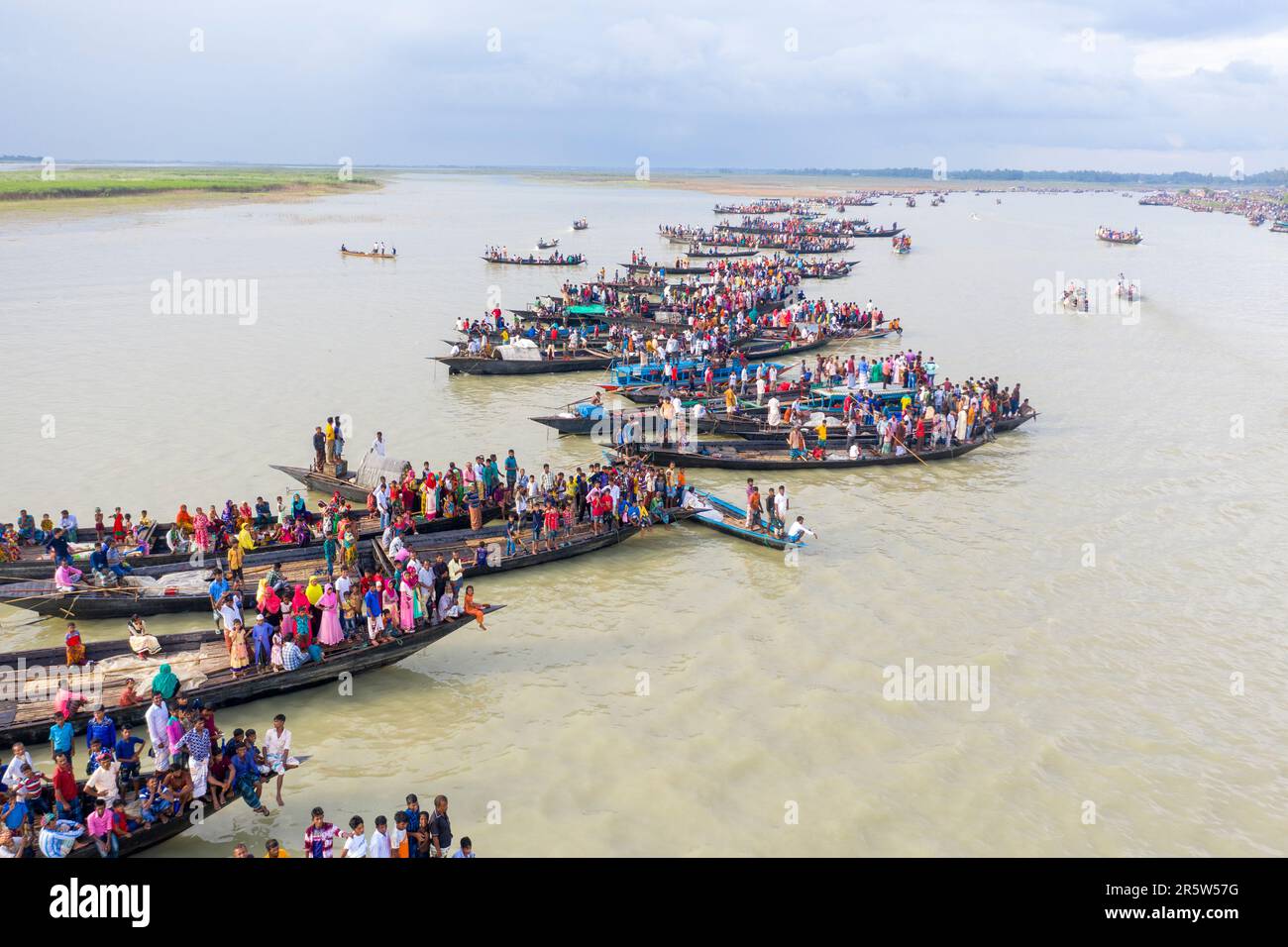 Spectators enjoying a traditional boat race on the Jamuna River ...
