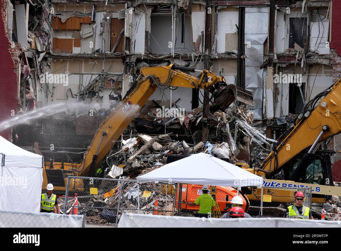 Workers move debris at the site of a building collapse, Monday, June 5 ...