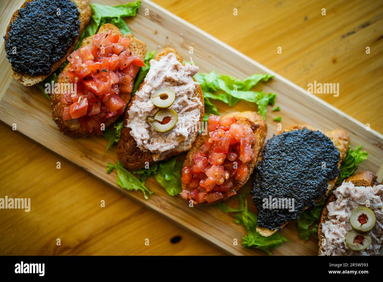 Selection of Spanish tapas served on a sliced baguette Stock Photo - Alamy