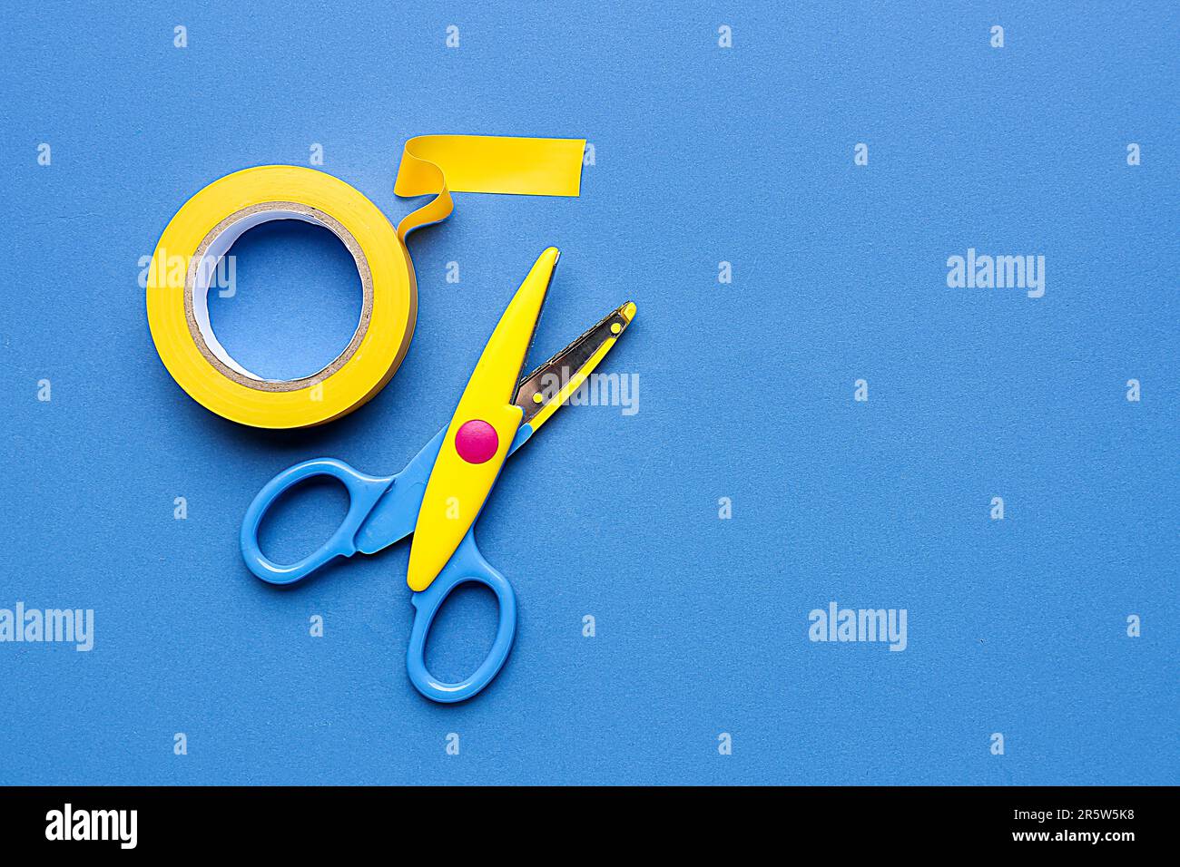 Adhesive tape roll and stationery scissors on blue background Stock ...