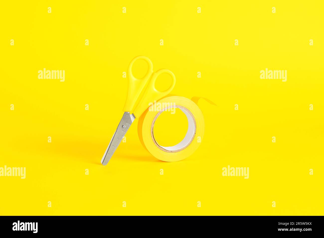 Adhesive tape roll and stationery scissors on yellow background Stock ...