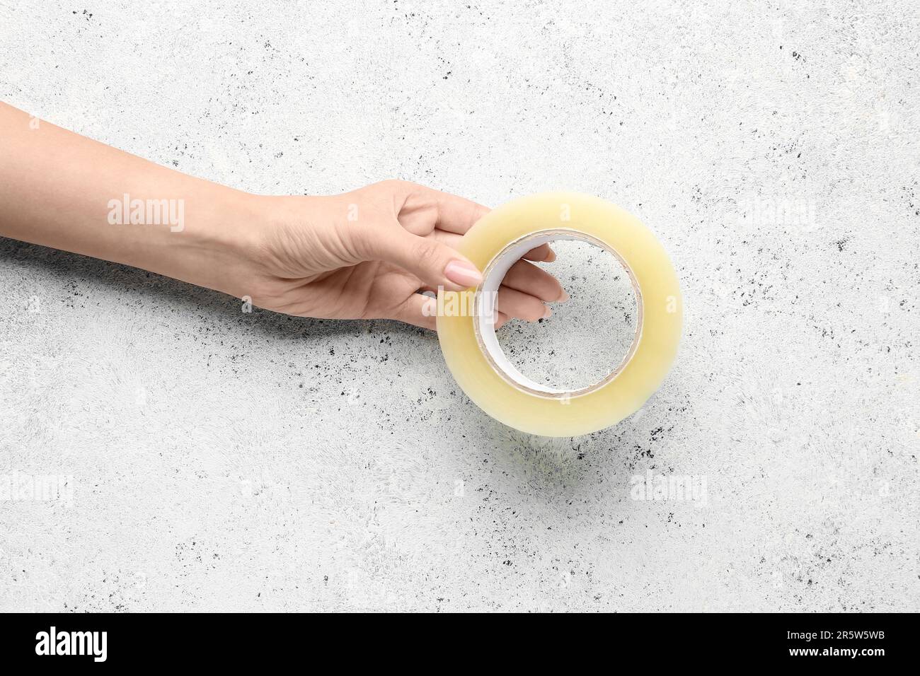Female hand holding adhesive tape roll on white background Stock Photo ...