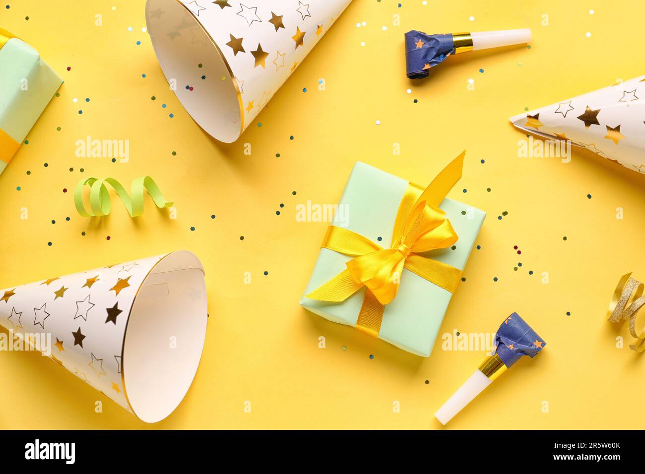 Different party decor on yellow background Stock Photo - Alamy