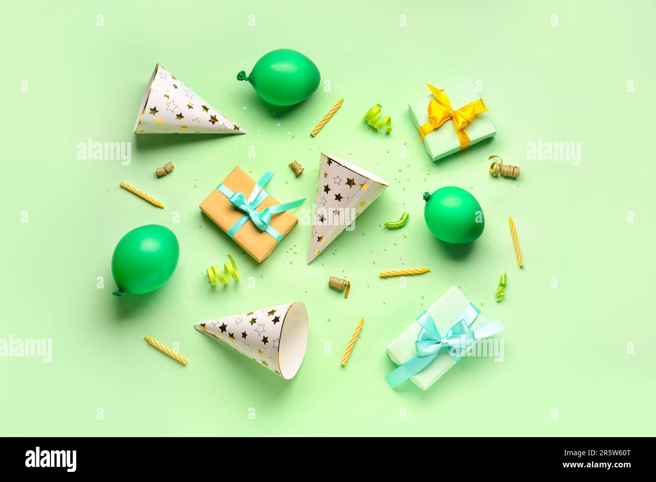 Different party decor on pale green background Stock Photo - Alamy