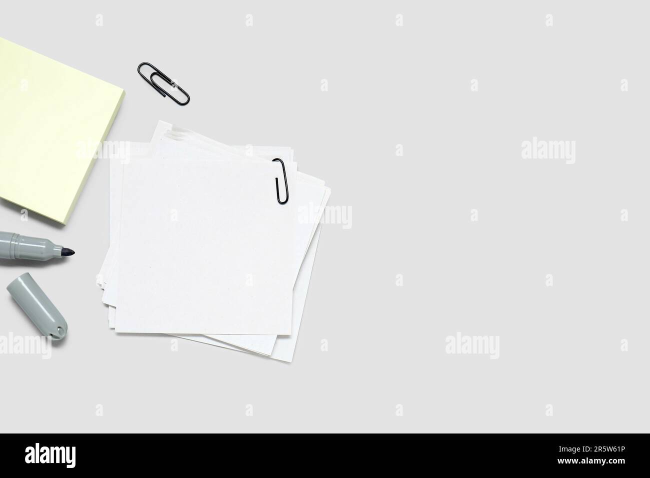 Sticky notes with paperclips and marker on grey background Stock Photo ...