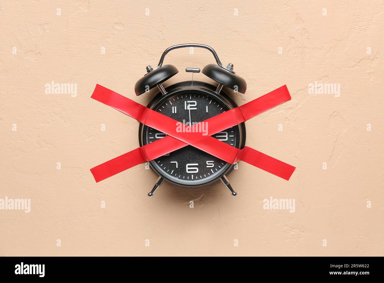 Alarm clock with cross made of adhesive tape on beige background Stock ...
