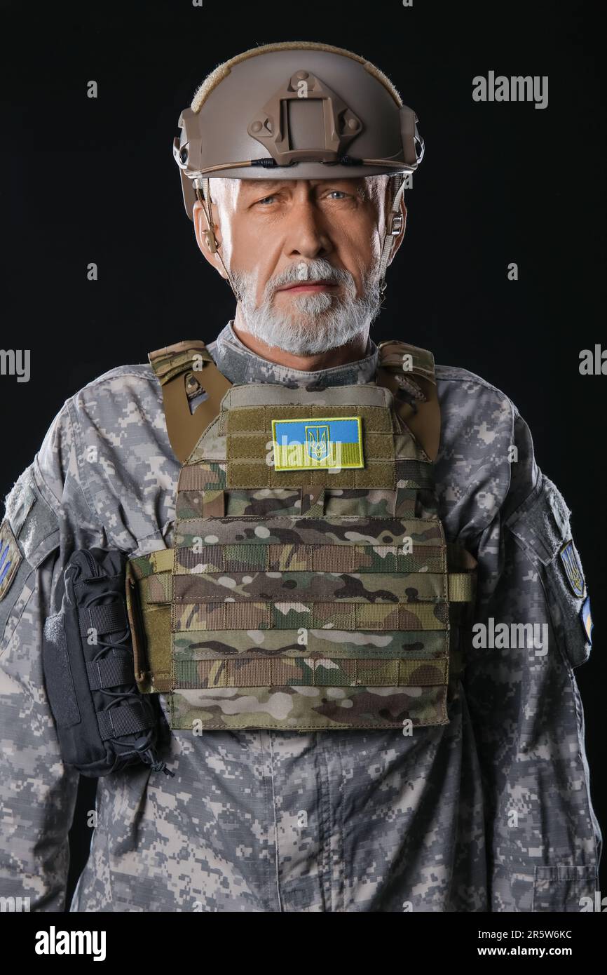 Mature soldier with Ukrainian patch on dark background Stock Photo - Alamy