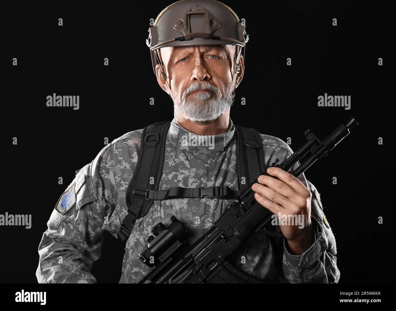 Mature soldier with assault rifle on dark background Stock Photo - Alamy