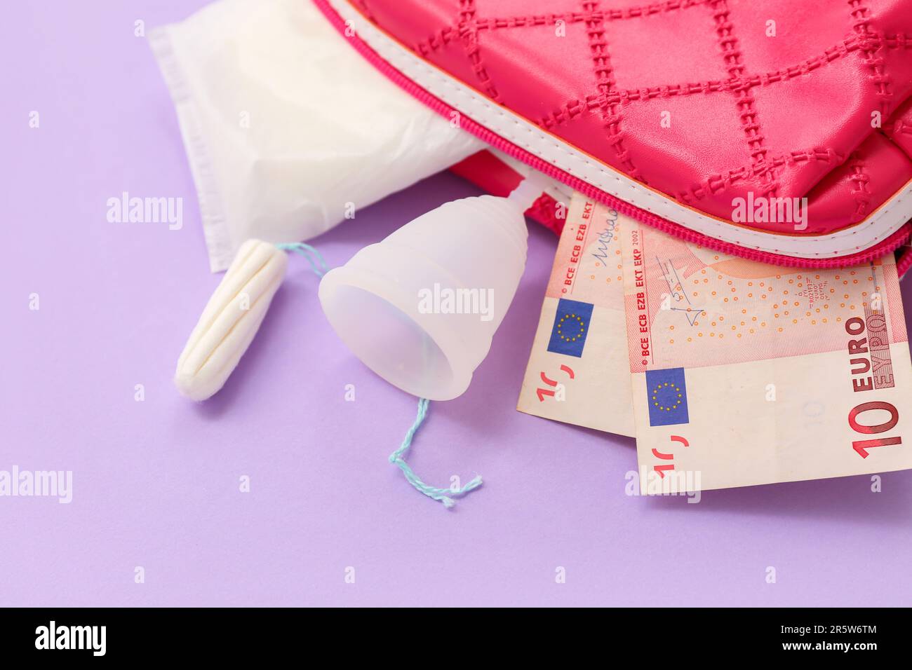 Lady's cosmetic bag with hygiene products and money on lilac background ...