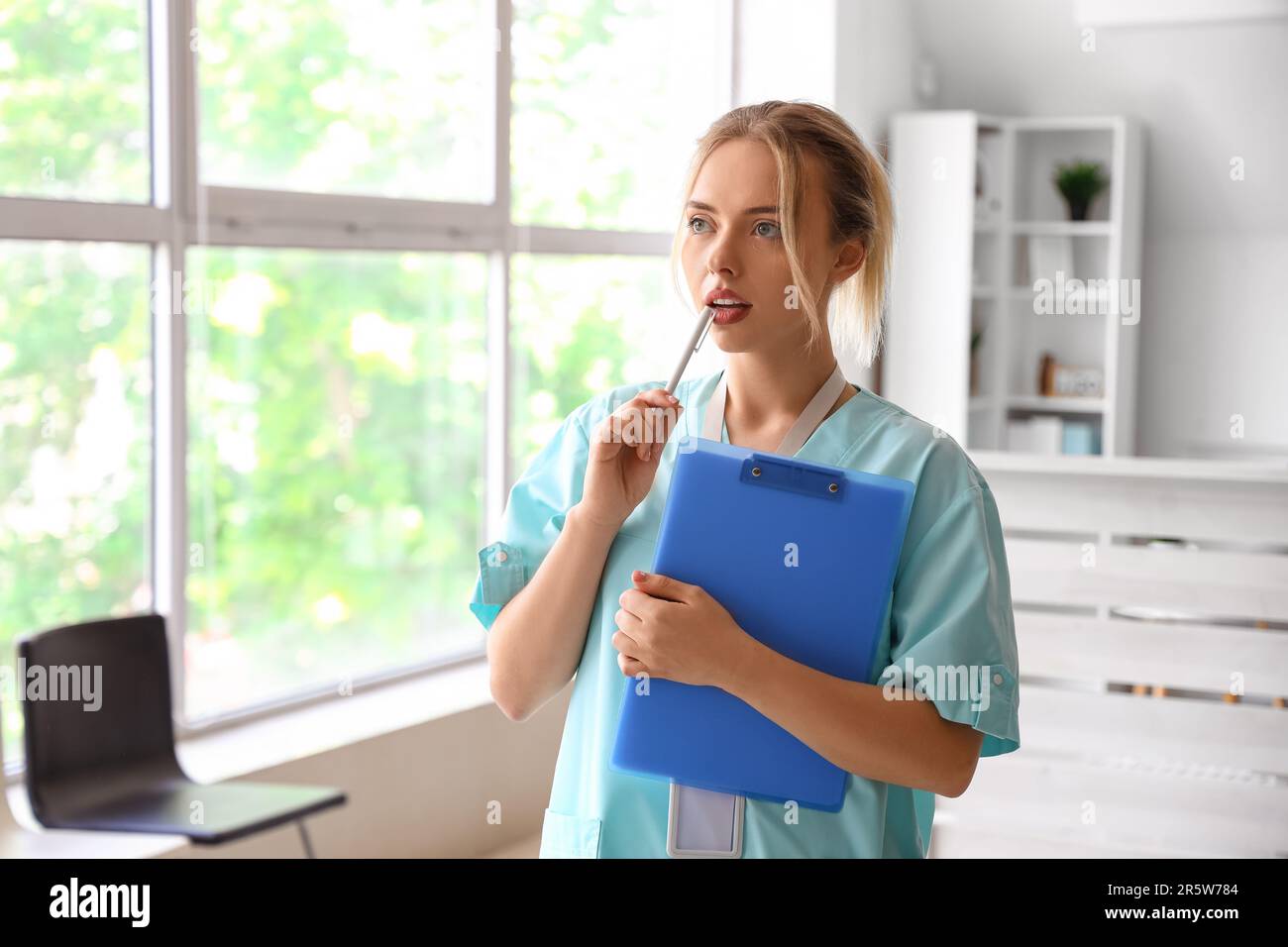 Female medical intern with clipboard in clinic Stock Photo - Alamy