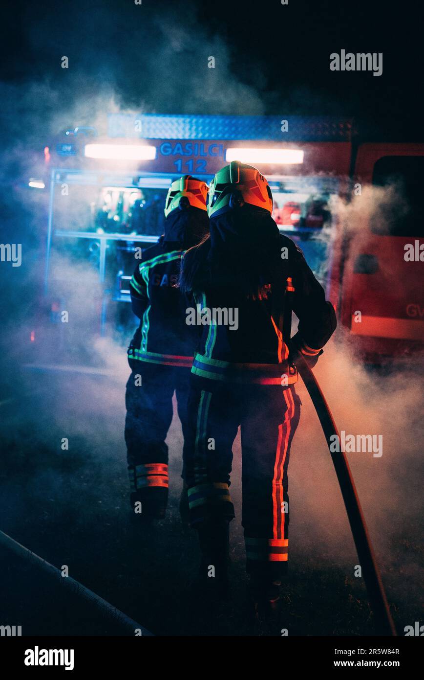 Firefighters responding to an emergency scene with smoke in the air and ...