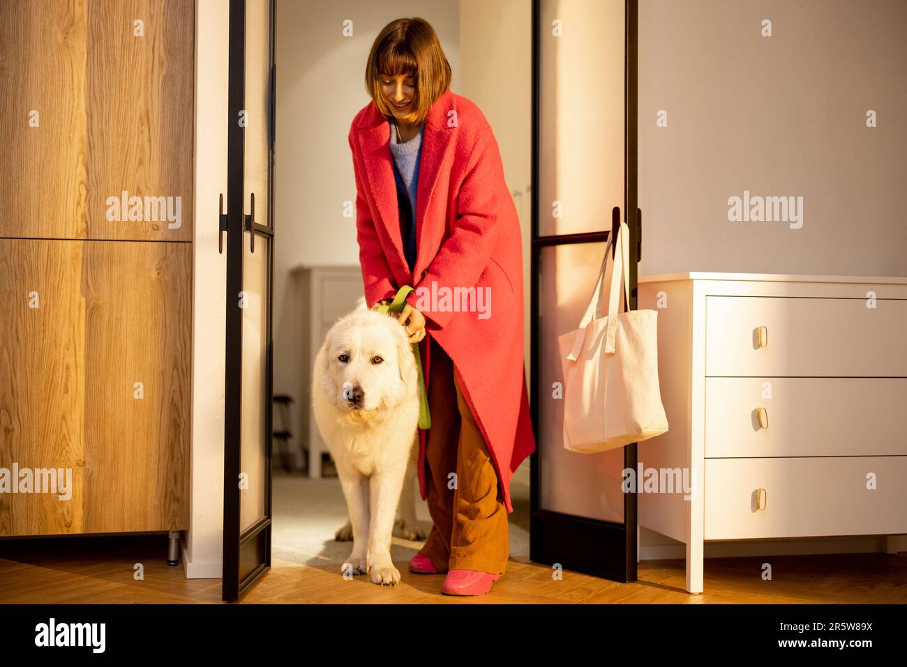 Woman comes home with her dog from a walk Stock Photo - Alamy