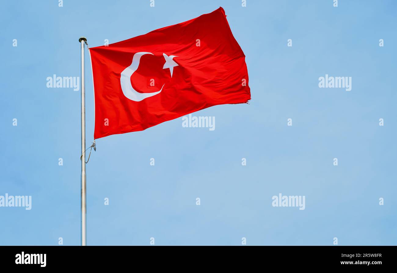 Republic of Turkey flag fluttering in the wind against a blue sky ...