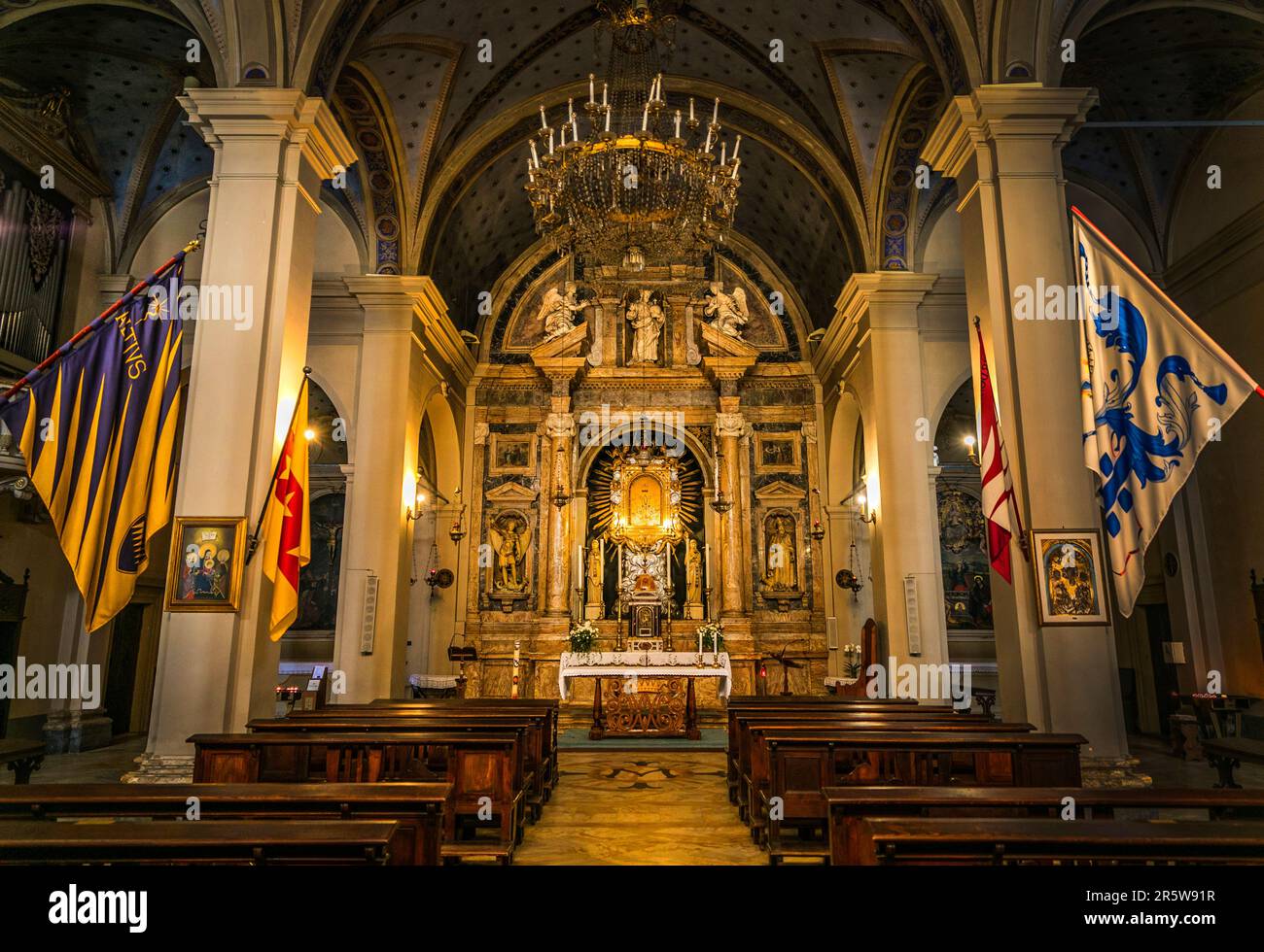 A grand church interior, featuring a large seating area with rows of ...