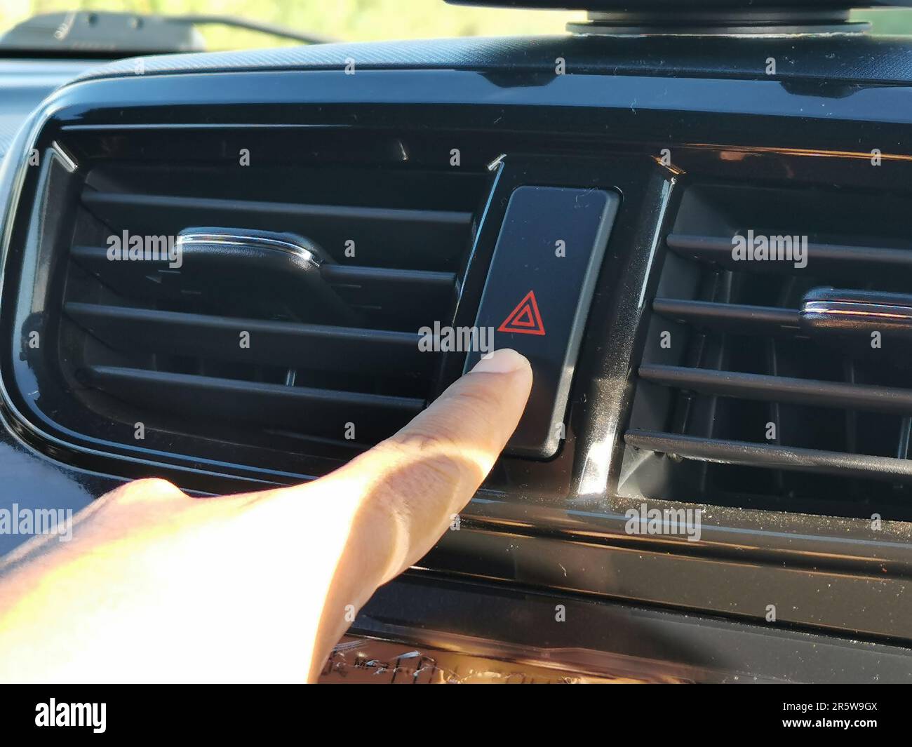 The hand pressing the emergency button on a car dashboard Stock Photo ...