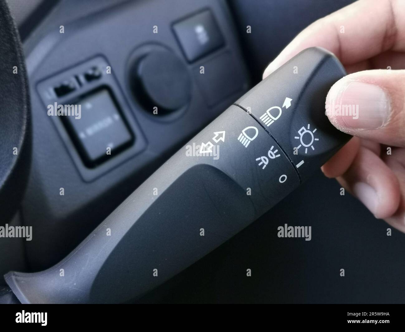 The hand turns on the car headlamp switch. Car interior details Stock ...