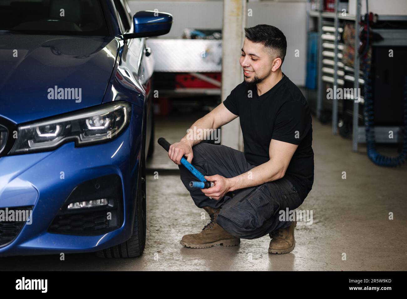 Handsome man mechanic checking tire service via insurance system at ...