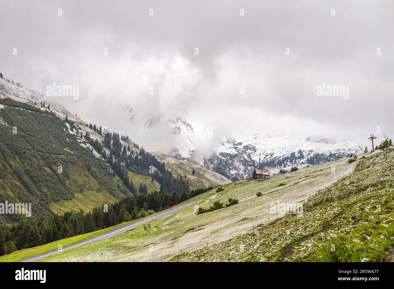 A breathtaking view of lush green hills and snow-capped mountains in ...