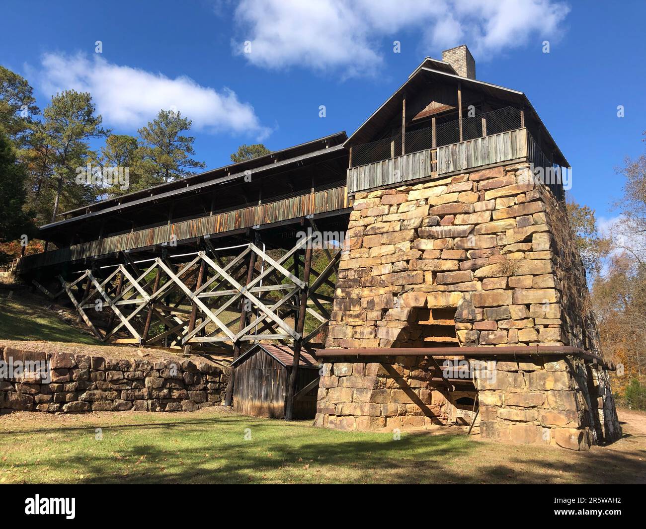 A large, two-story wooden structure featuring a set of stairs leading ...