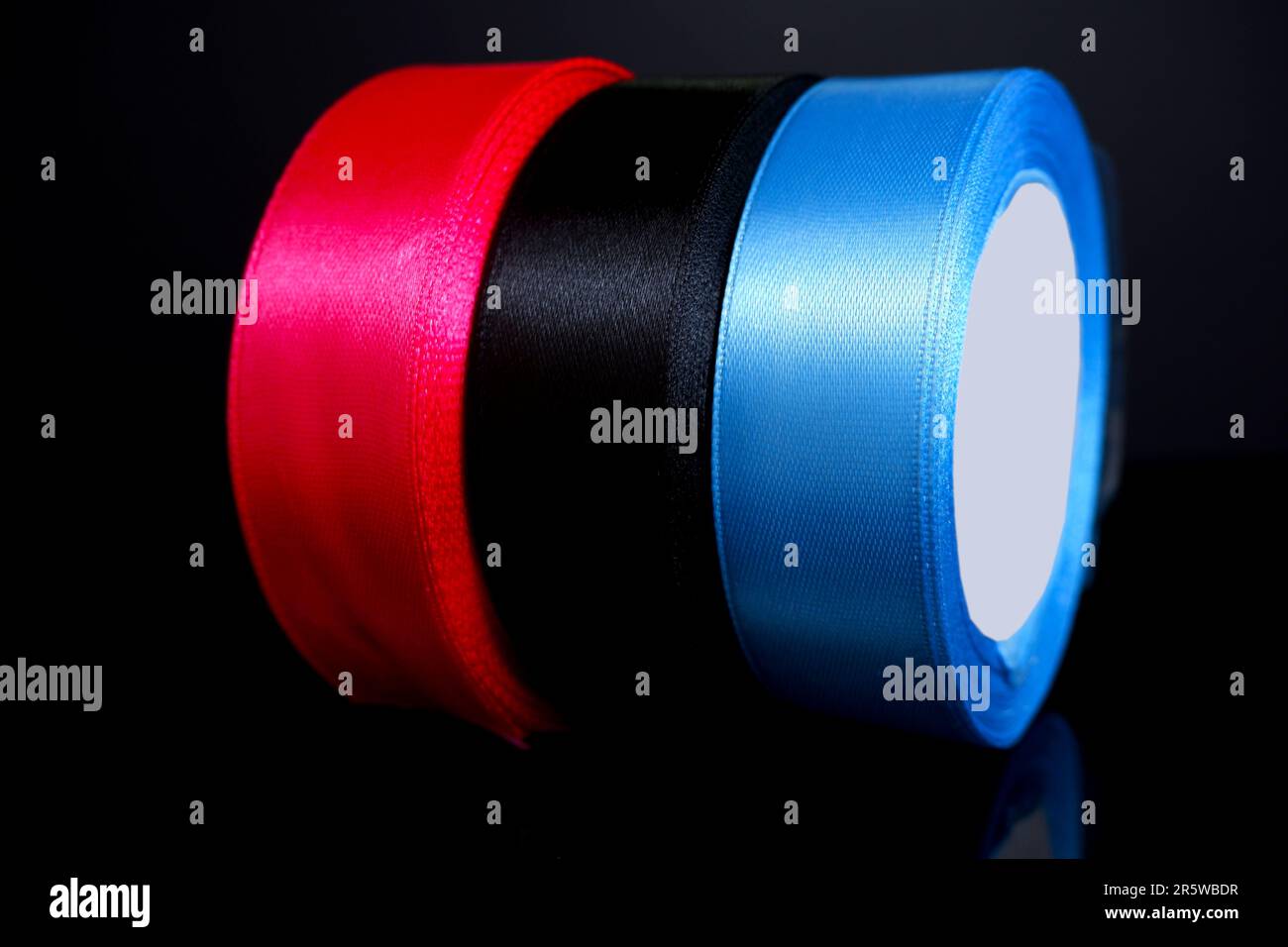 A group of colorful ribbons are arranged on top of a black background ...