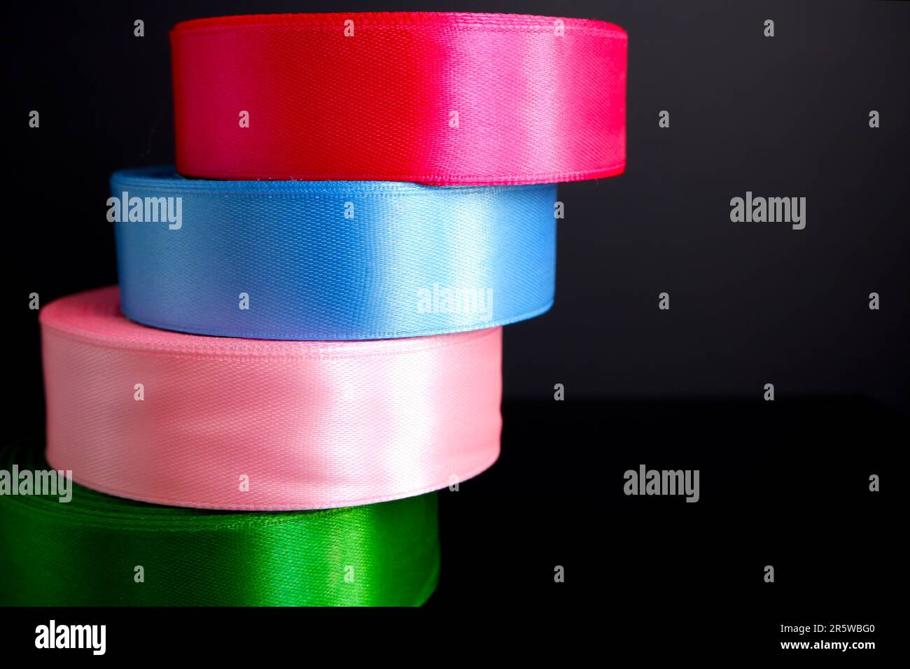 A group of colorful ribbons are arranged on top of a black background ...