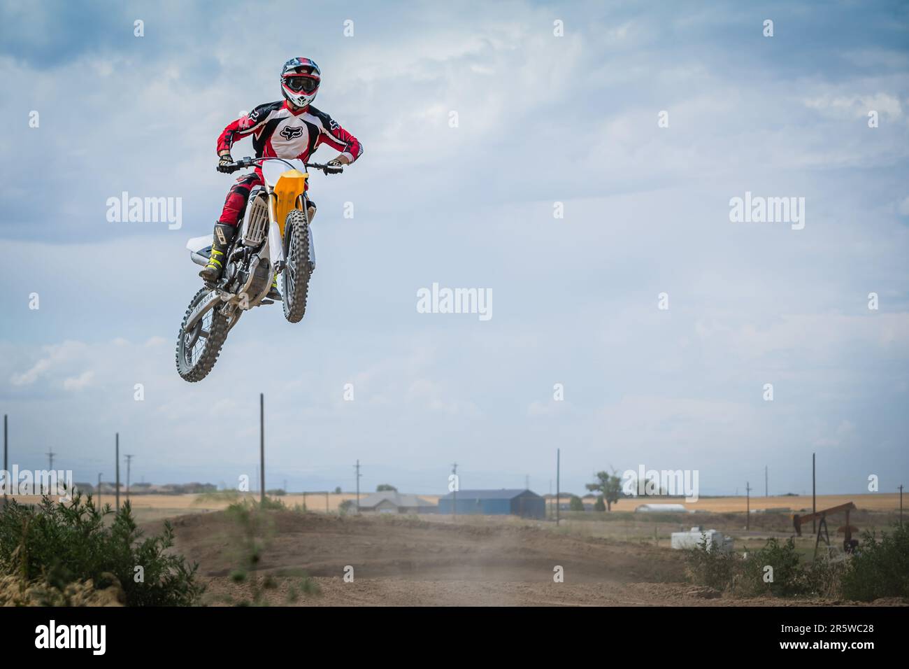 A Caucasian male in a bright yellow motocross helmet, riding a yellow ...