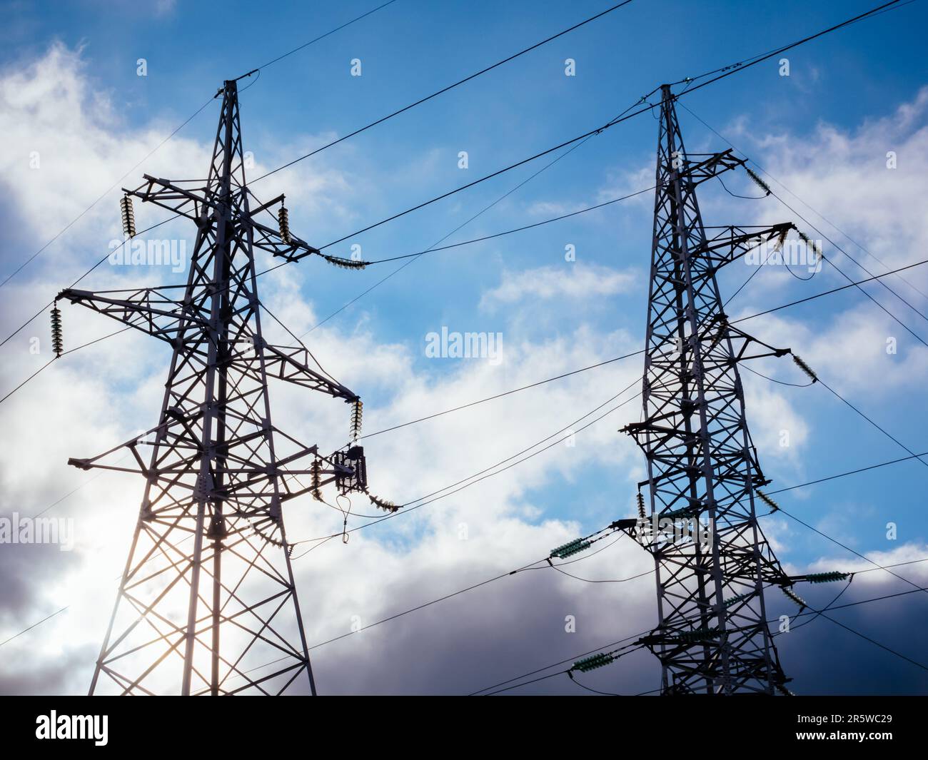 High voltage electricity pillars on the blue sky background with clouds ...
