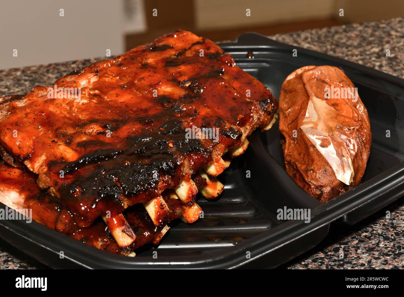 Barbequed spareribs in a plastic container. BBQ ribs Stock Photo - Alamy