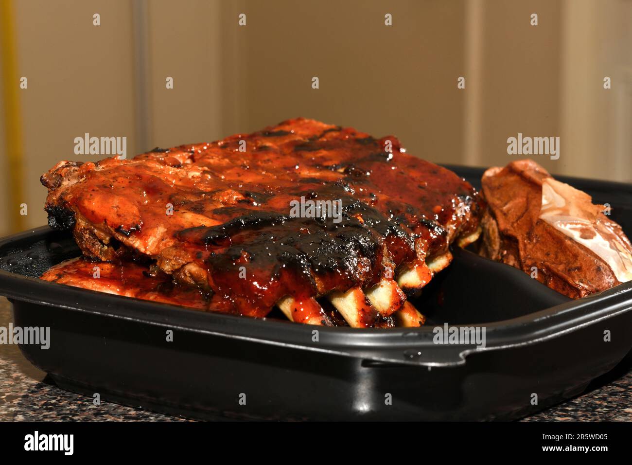 Barbequed spareribs in a plastic container. BBQ ribs Stock Photo - Alamy