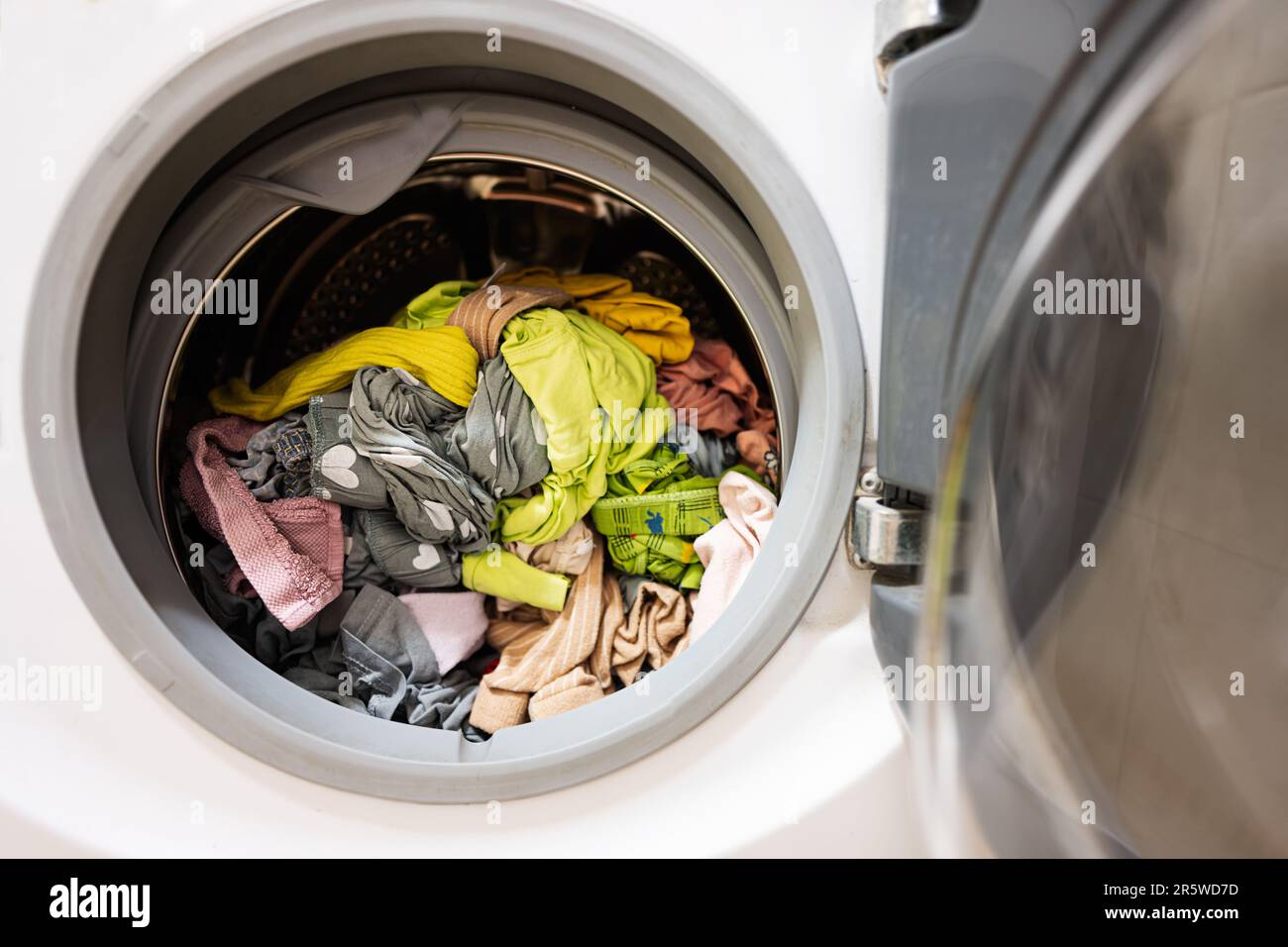 Washing machine with a lot of dirty clothes in the laundry room Stock ...
