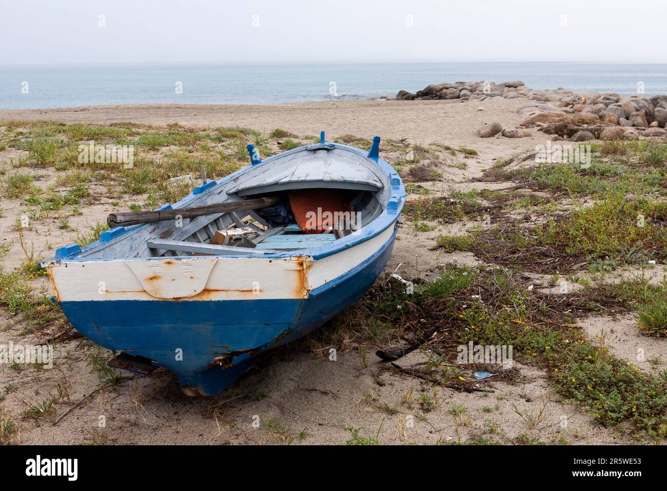An abandoned old fishing boat on the beach at Roccella Ionica, Calabria ...