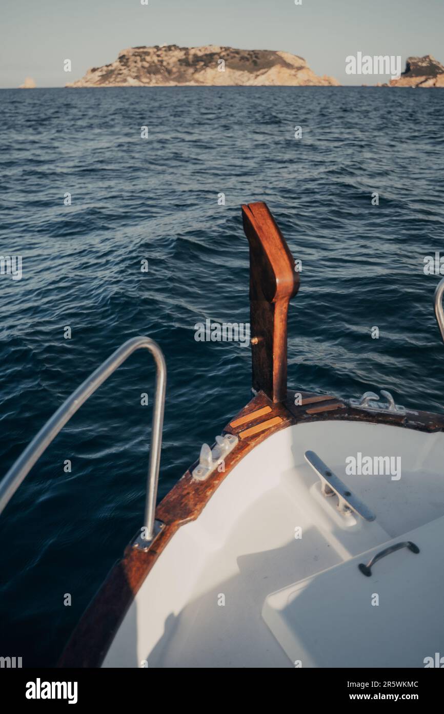 A bow of a boat facing forward in a body of water with an island of ...