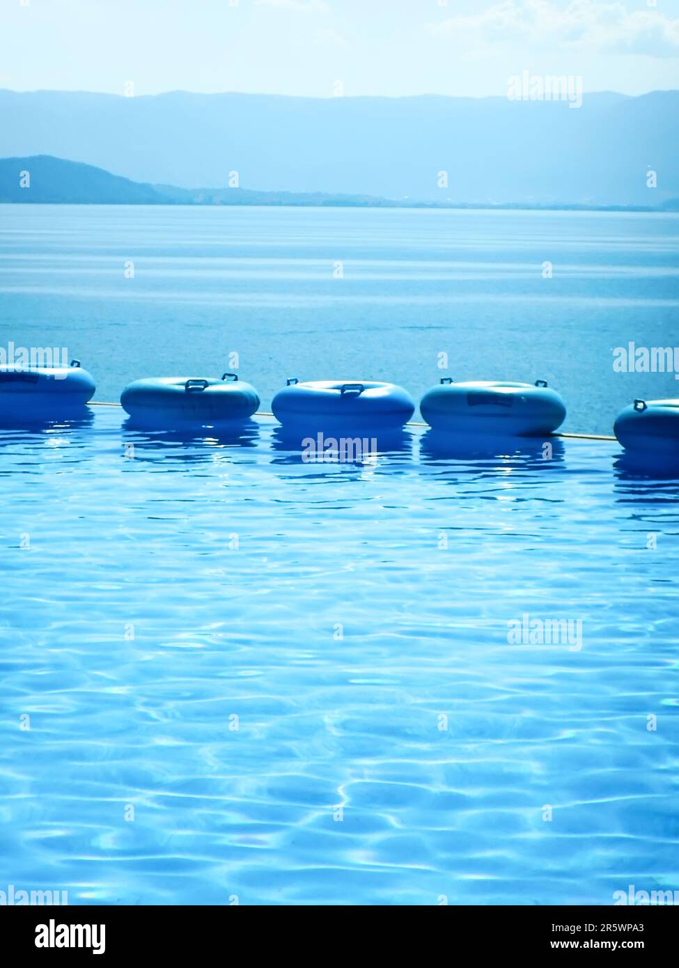 Infinity swimming pool with sea and Mountain View, blue float Stock ...