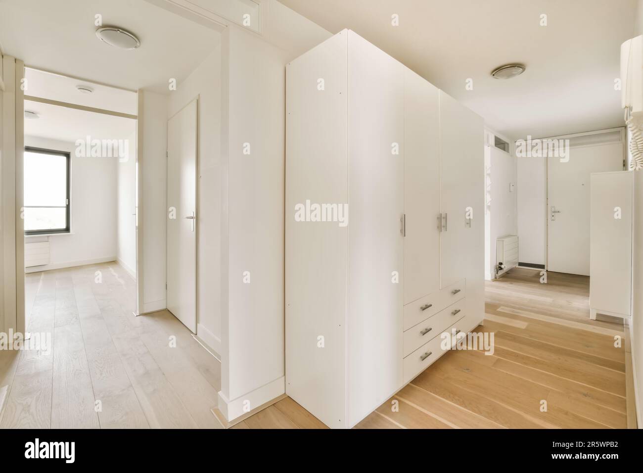 an empty room with wooden floors and white walls, there is a large ...