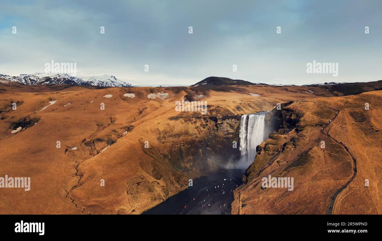 Drone shot of nordic skgafoss waterfall falling down off of frozen ...