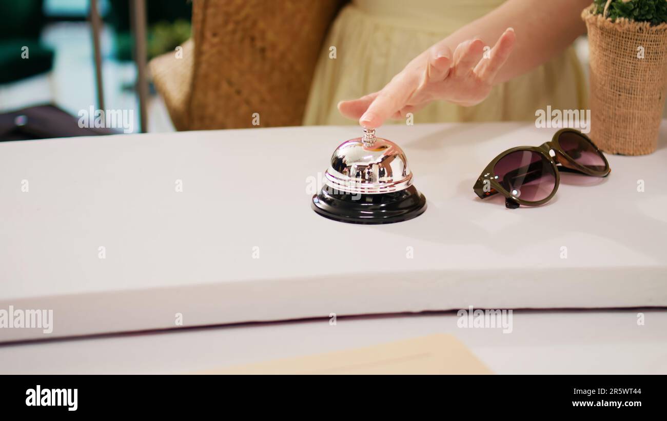 Impatient hotel guest using service bell at reception counter, calling ...