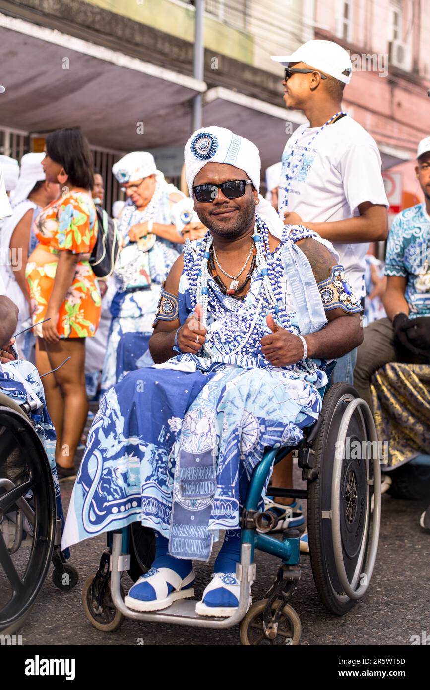 A cheerful African male in a wheelchair wearing a vibrant traditional ...