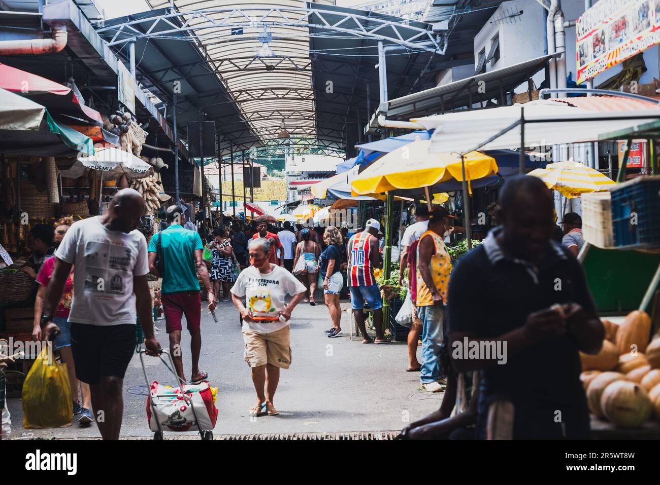 An eclectic bustling market with a diverse crowd of people meandering ...