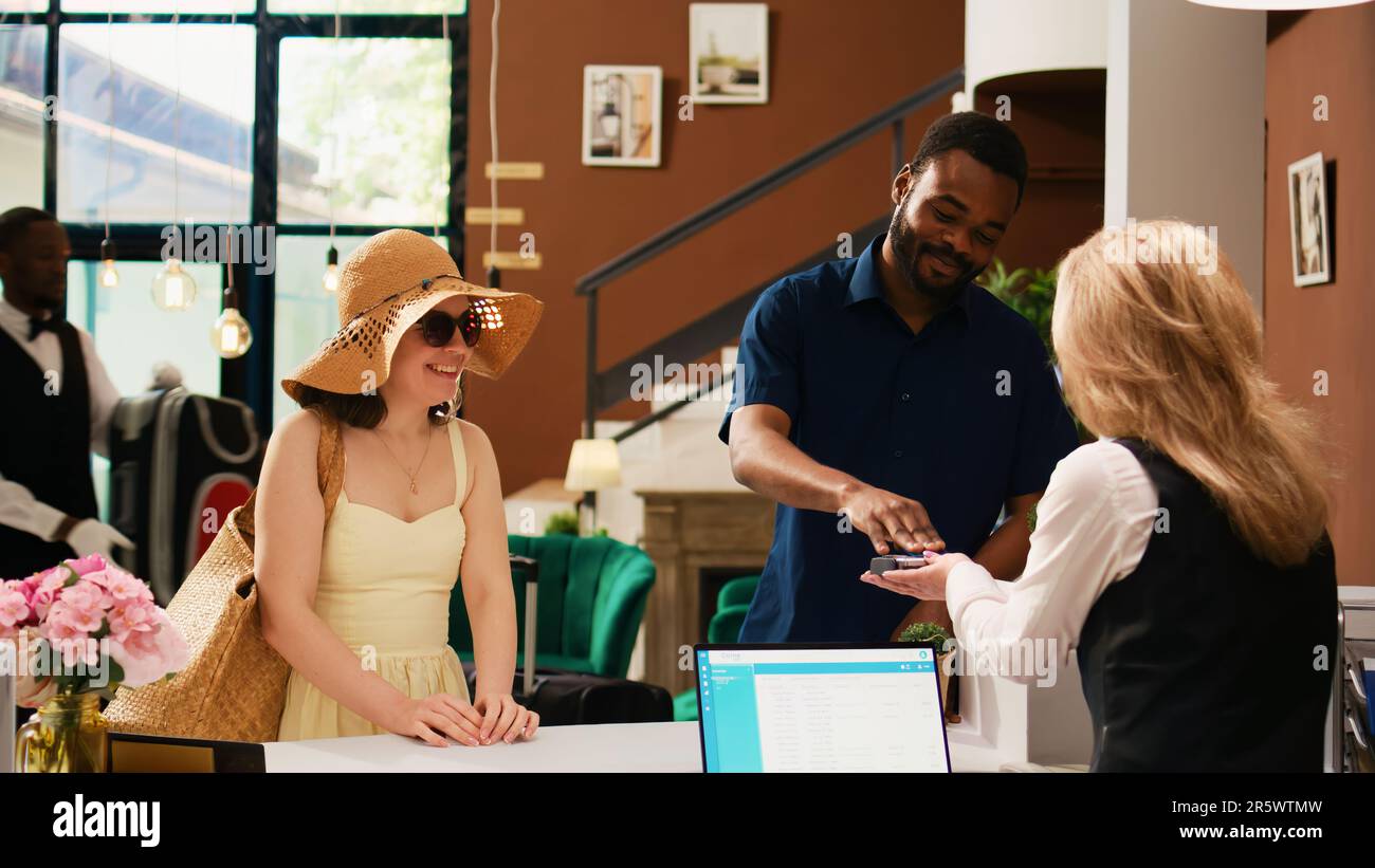 Couple paying room accommodation at check in, making payment at pos ...