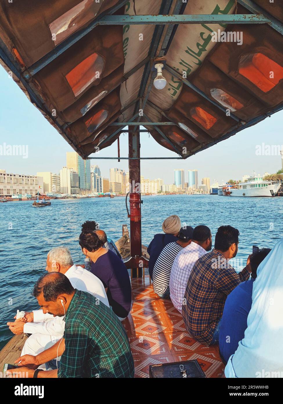 A group of people enjoying a ride on a traditional wooden boat, at Al ...