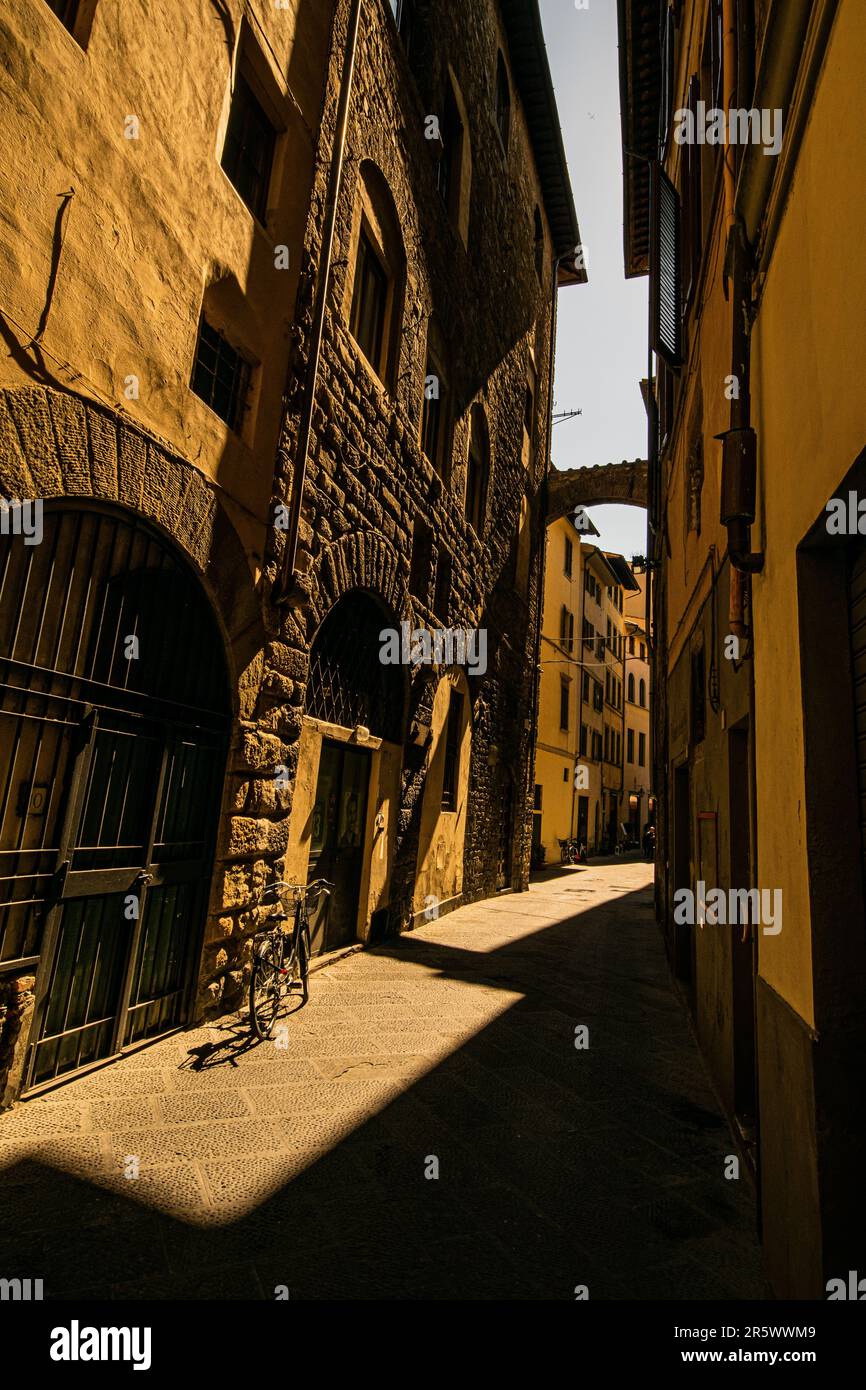 A dimly lit alley illuminated by the setting sun, creating a long ...