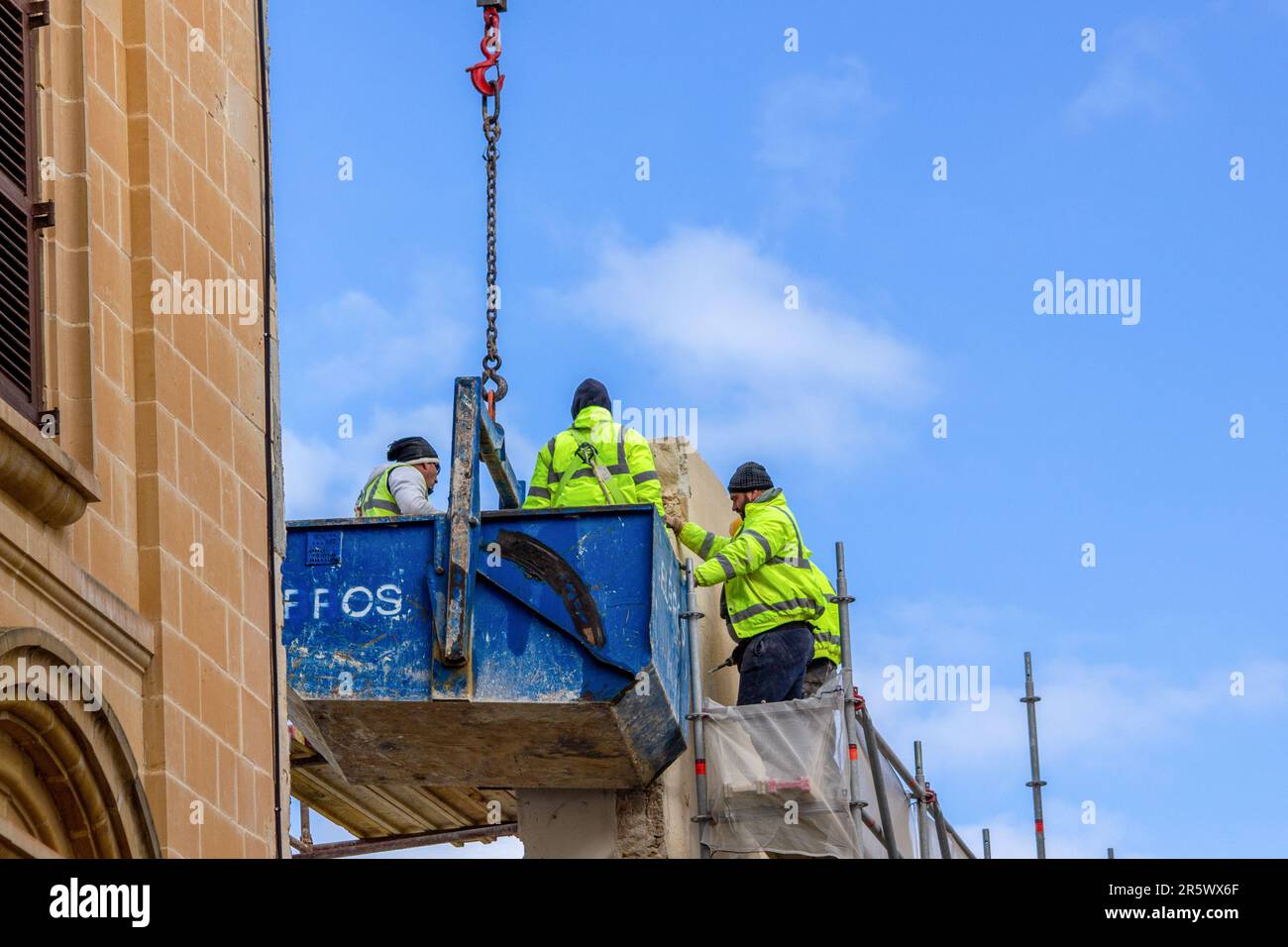 The workers on a raised platform, lifting off a large, rectangular structure Stock Photo - Alamy