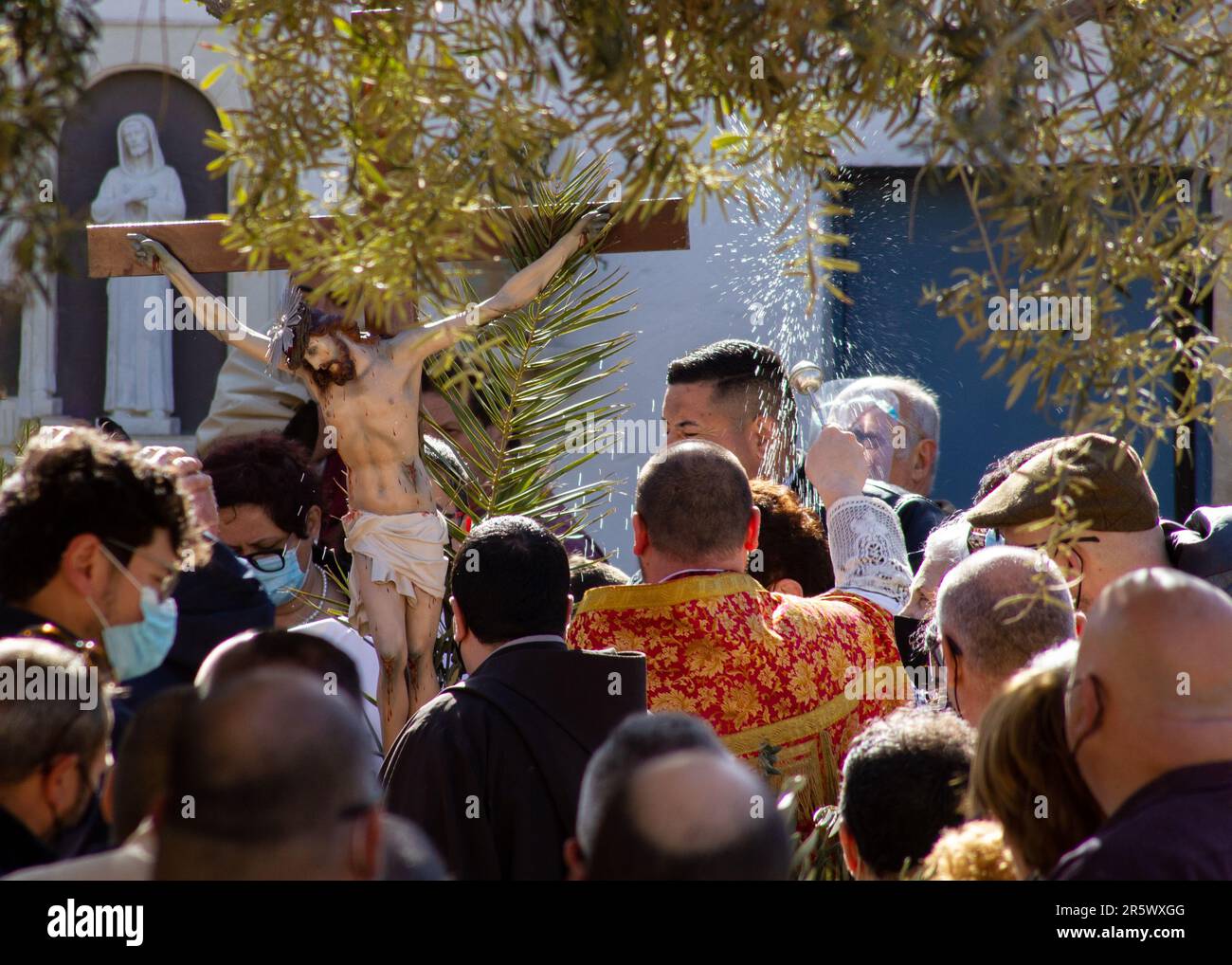 A large group of people gathered in a spiritual setting, holding a ...