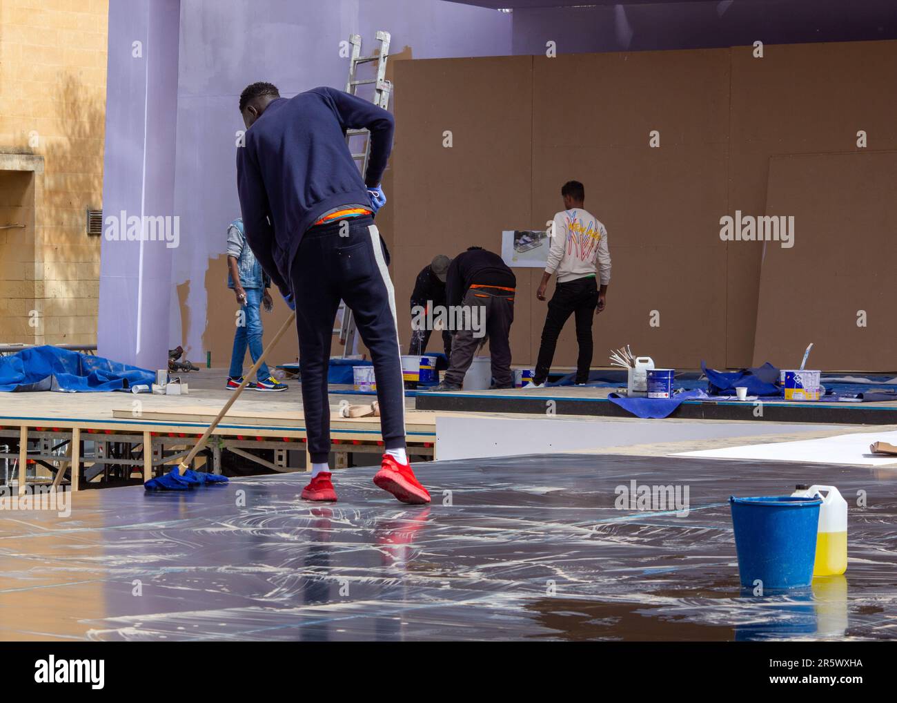 A diverse group of construction workers collaborate on a construction ...