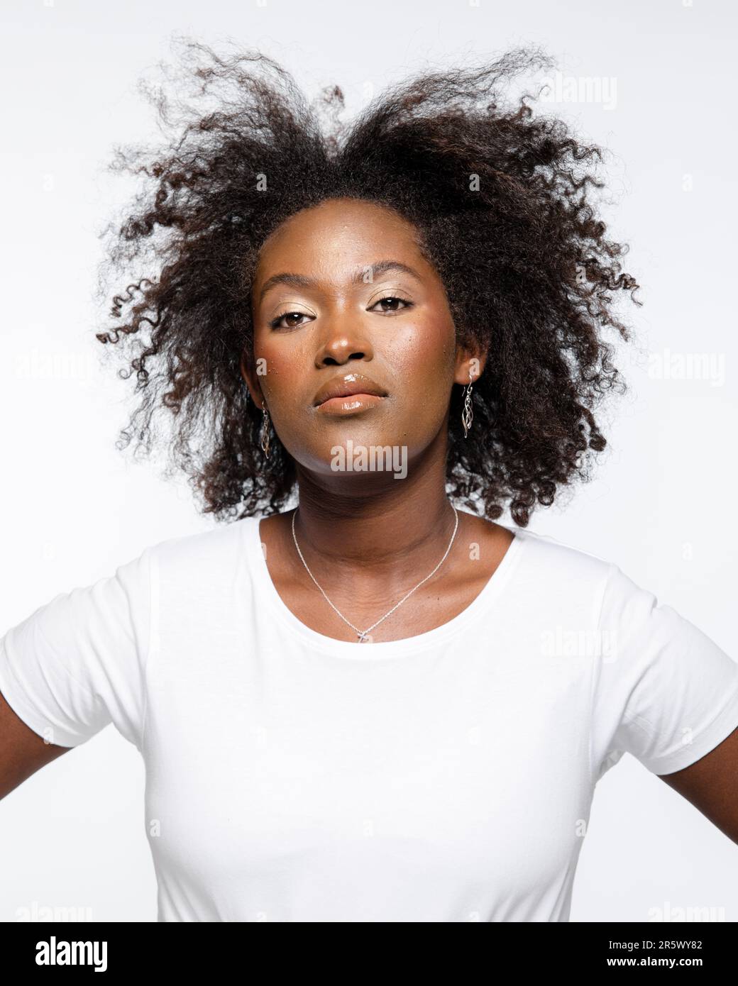 A young woman with long, dark hair styled in natural waves wearing a ...