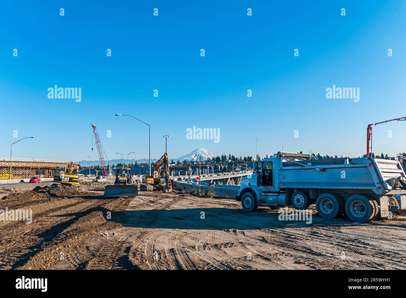A dump truck, a crane, a bulldozer, and two power shovels on a track ...